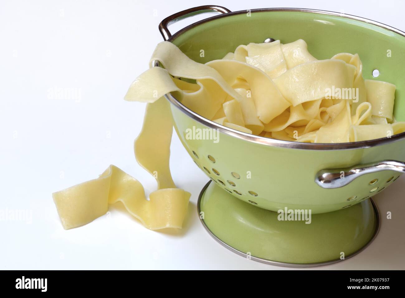 Pappardelle, cooked, wide Italian ribbon noodles in kitchen sieve ...