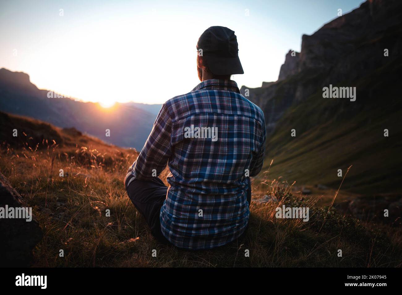 Lonely Man sitting on a mountain for watching Sunrise views alone ...