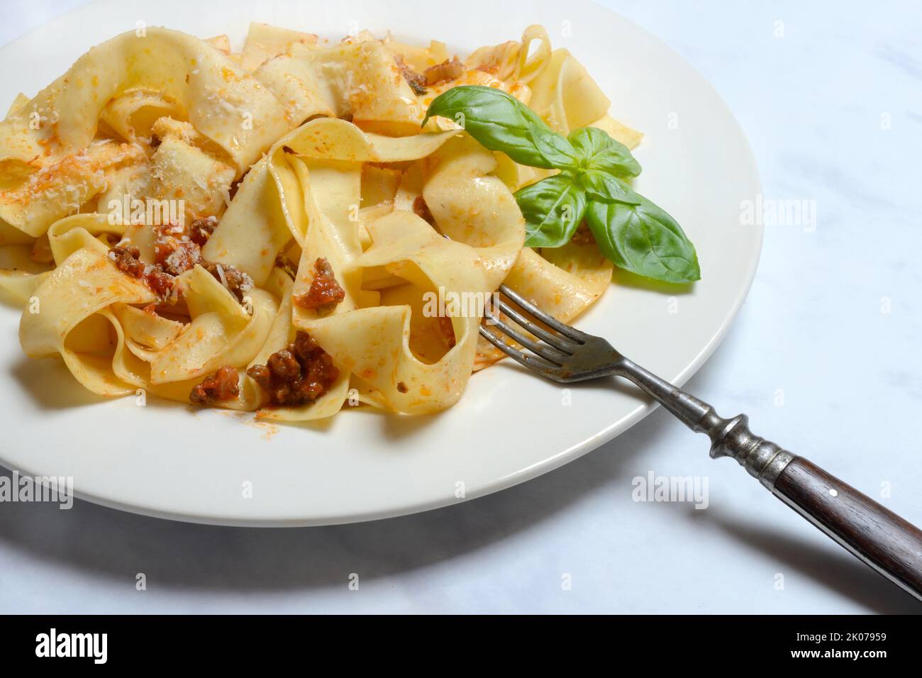 Pappardelle, cooked, wide Italian ribbon noodles with Bolognese sauce ...