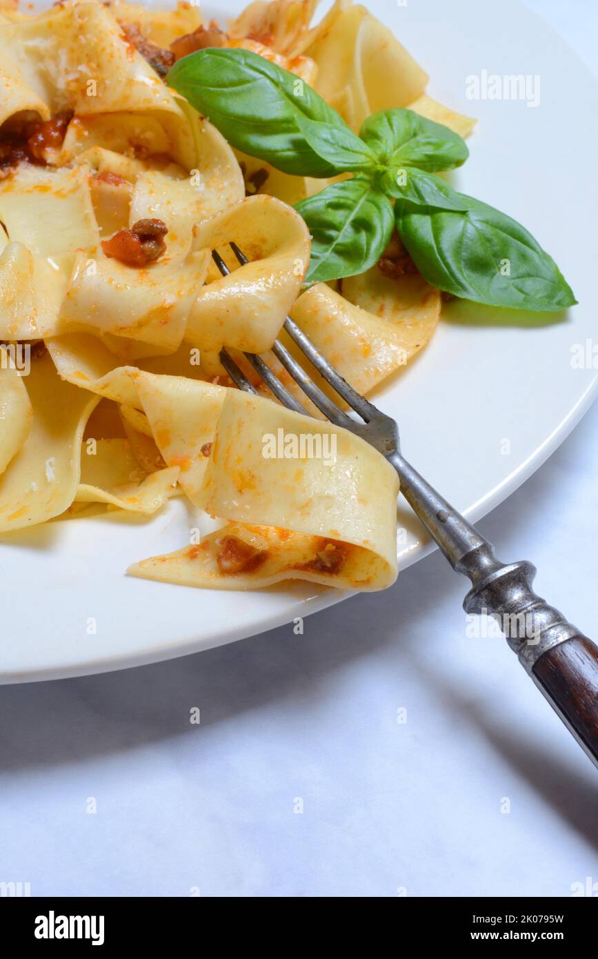 Pappardelle, cooked, wide Italian ribbon noodles with Bolognese sauce ...