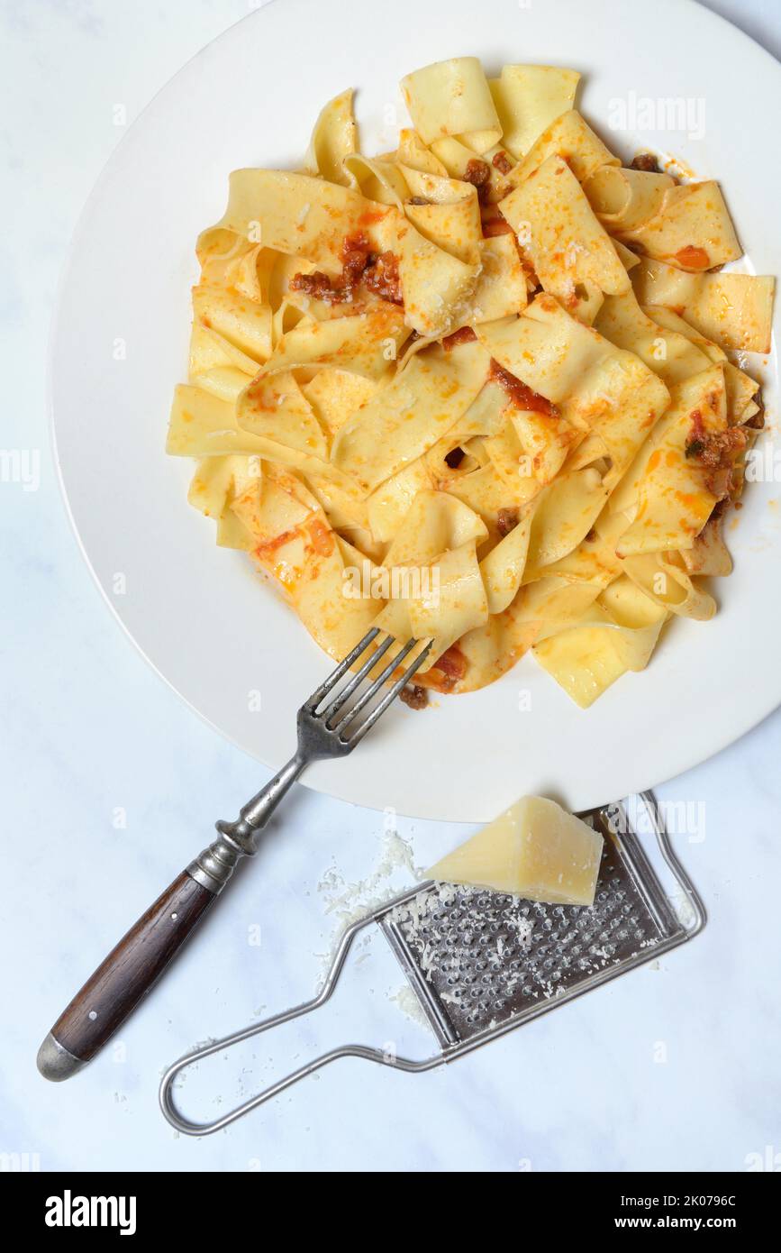 Pappardelle, cooked wide Italian ribbon noodles with Bolognese sauce on ...