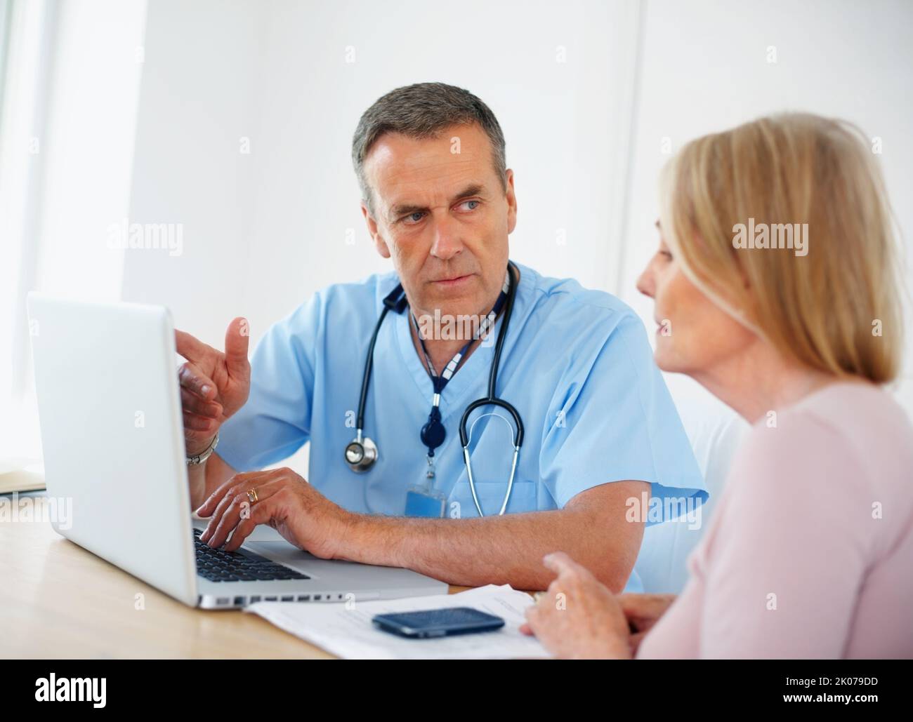 Medical doctor discussing with female patient using laptop. Portrait of ...