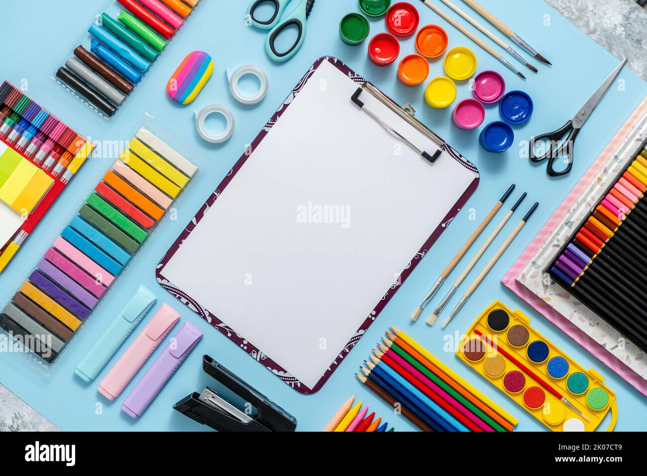 Colorful school supplies placed on blue background with white plain ...