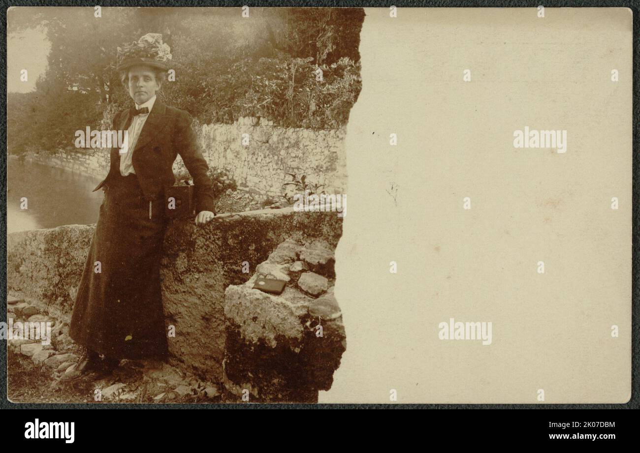 Frances Benjamin Johnston, full-length portrait, posing by a wall with ...