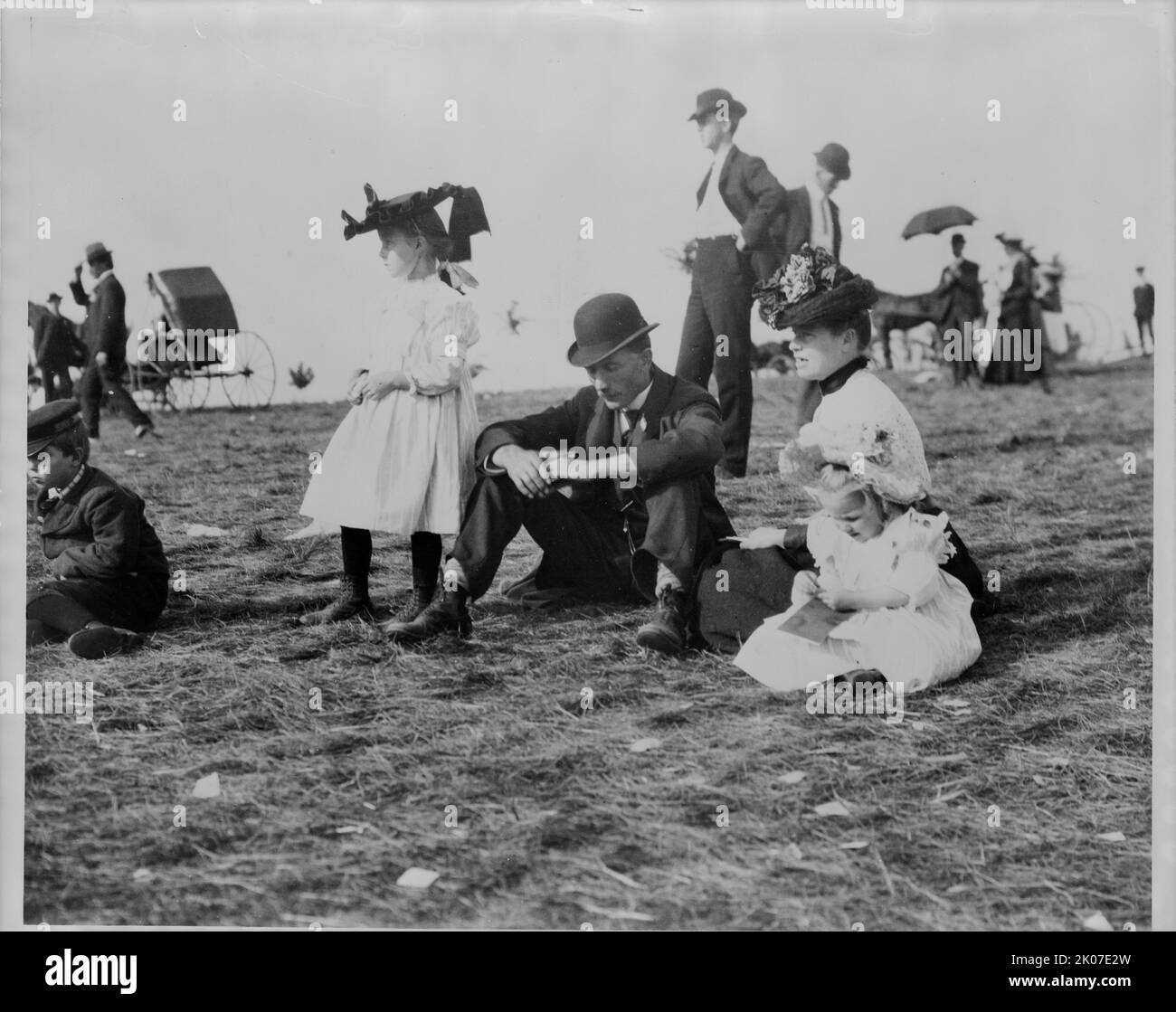 Parents and children seated on grass at state fair, St. Paul, Minnesota ...