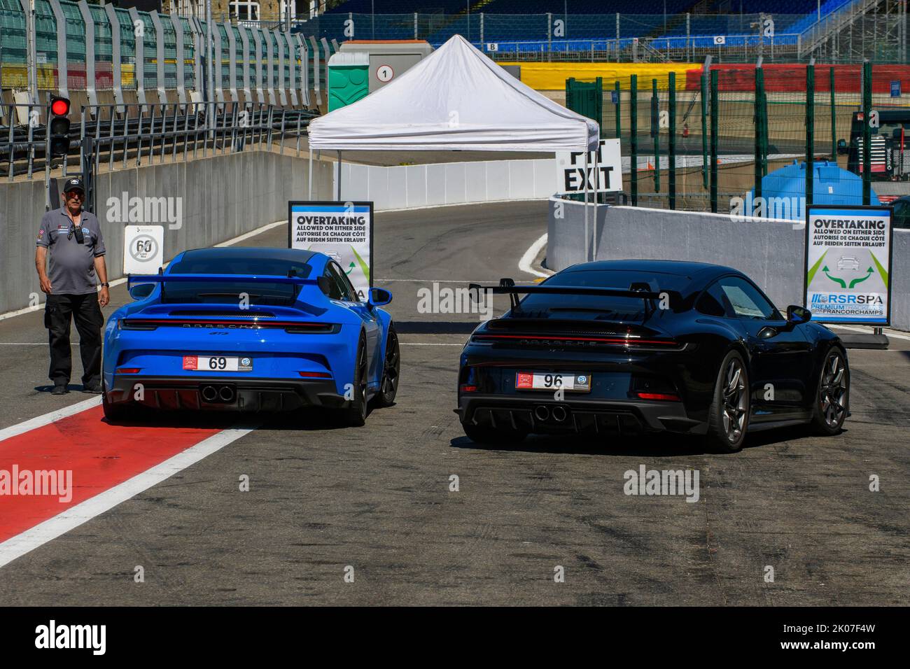 Two Porsche GT3 sports cars waiting at red lights at pit lane exit for ...