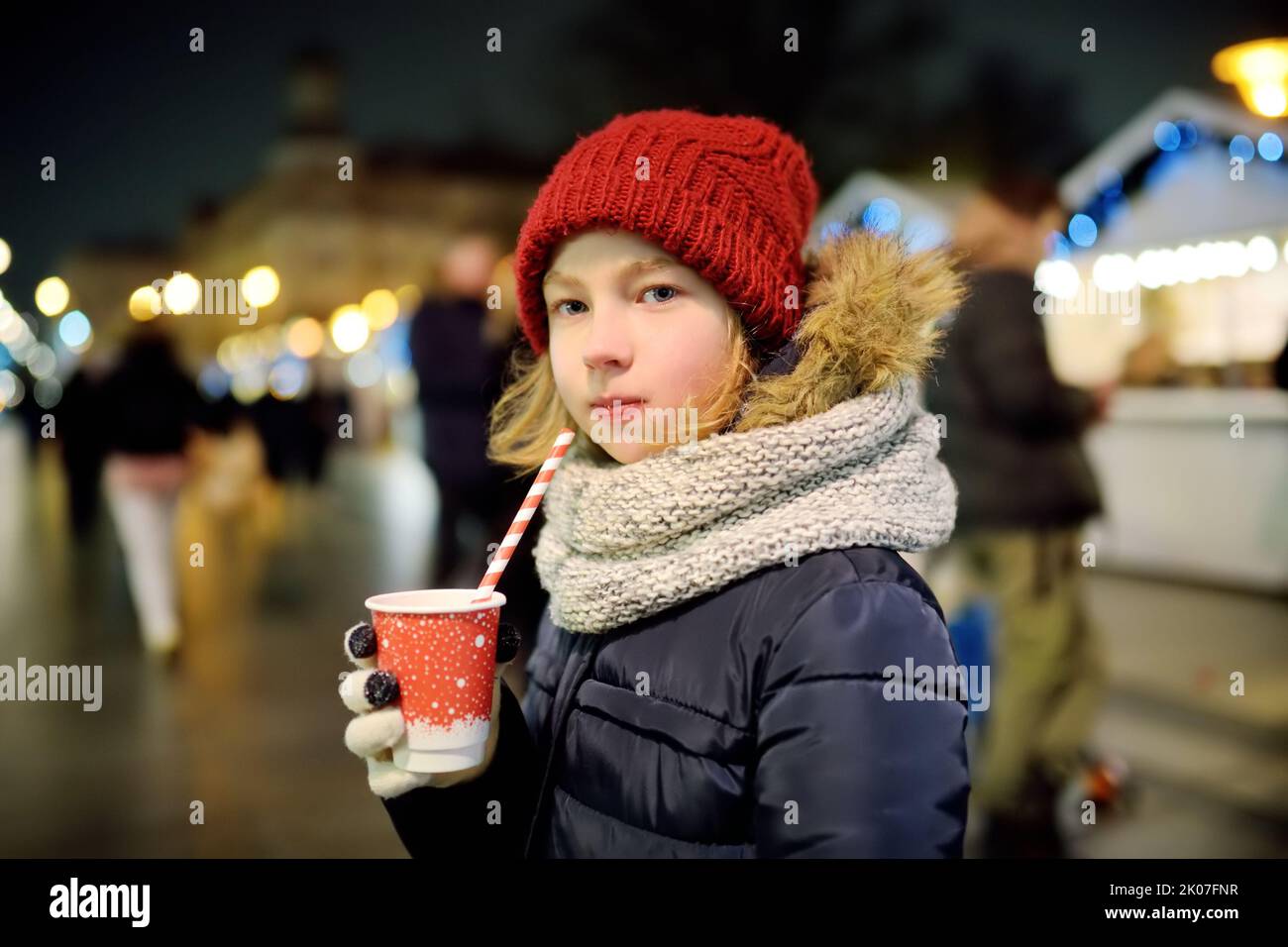 Cute young girl drinking hot chocolate on traditional Christmas fair in ...