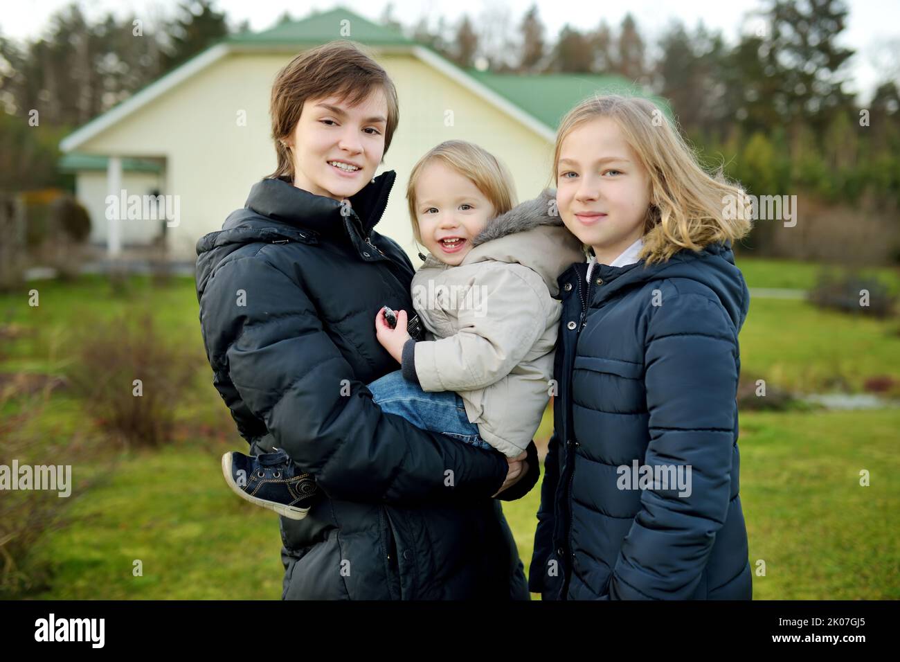 Two big sisters and their toddler brother having fun outdoors. Two ...