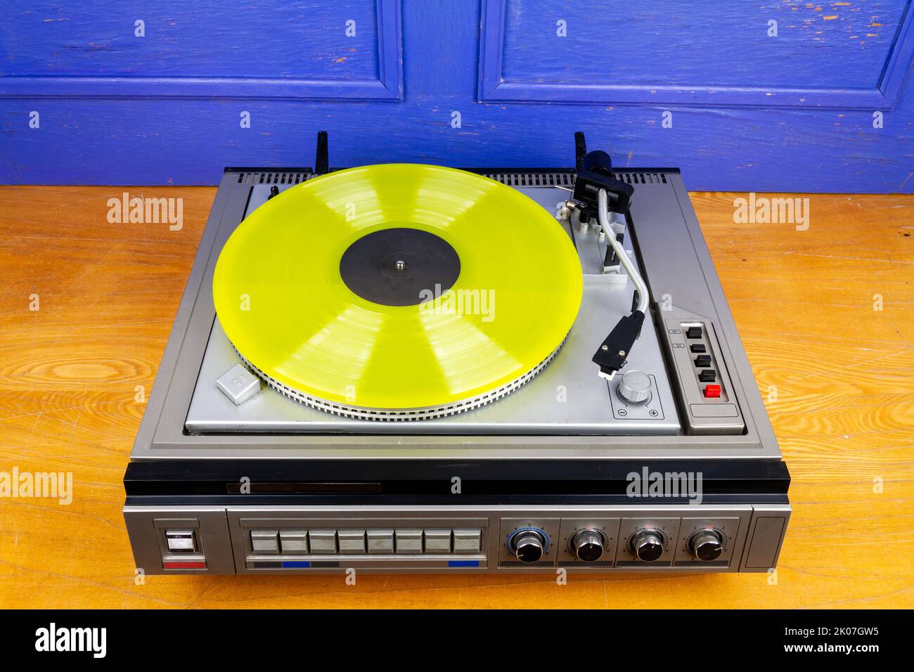 Vintage turntable vinyl record player with yellow vinyl on a table ...