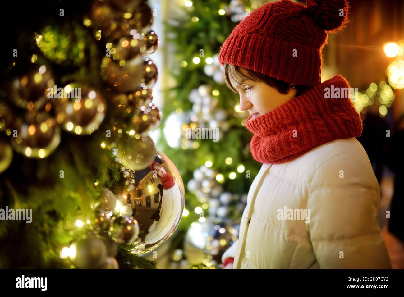 Cute young girl admiring Christmas lights and decorations on the ...