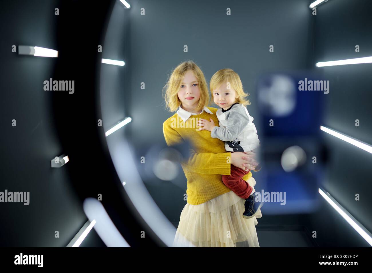 Big sister and her toddler brother taking a selfie picture with mobile ...