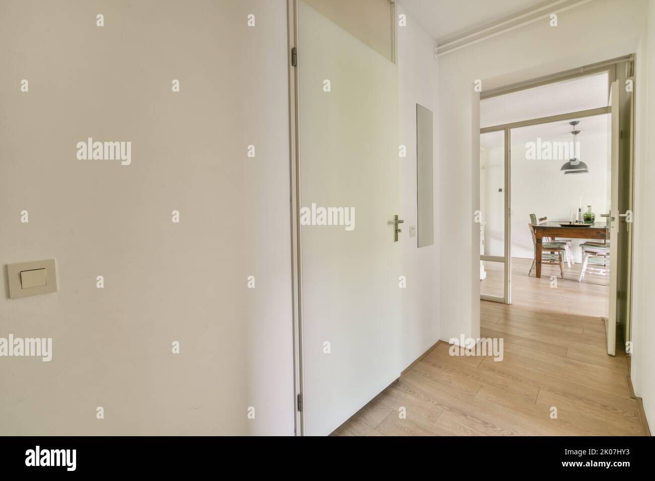 Interior of narrow corridor with telephone and many doors in daylight ...