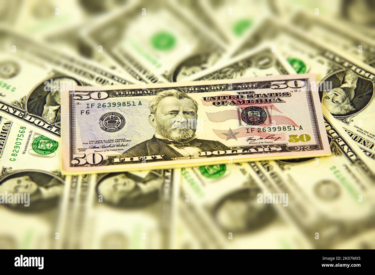 A pile of one dollar notes and a fifty dollar note on top with special ...