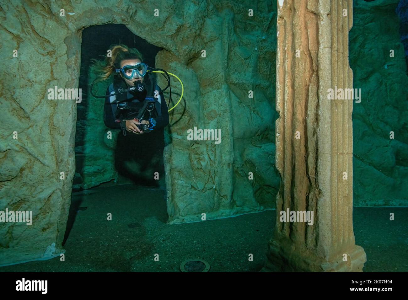 Diver dives through small gate of stylised ruin of ancient temple in 20 ...