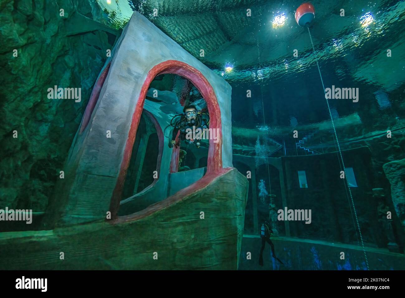 Female diver dives in 10 metres depth in indoor diving tower through ...