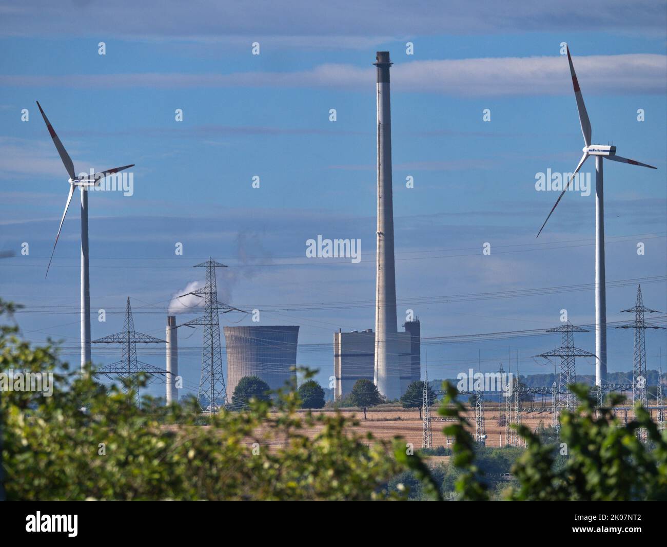 The Buschhaus lignite-fired power plant, next to it wind turbines, in ...