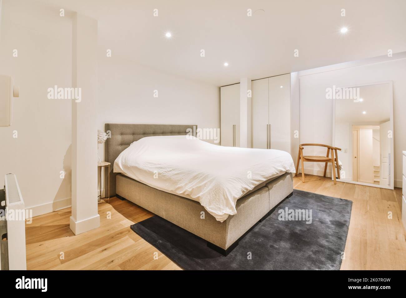 Home interior design of bedroom with bed and wooden wardrobe placed in ...