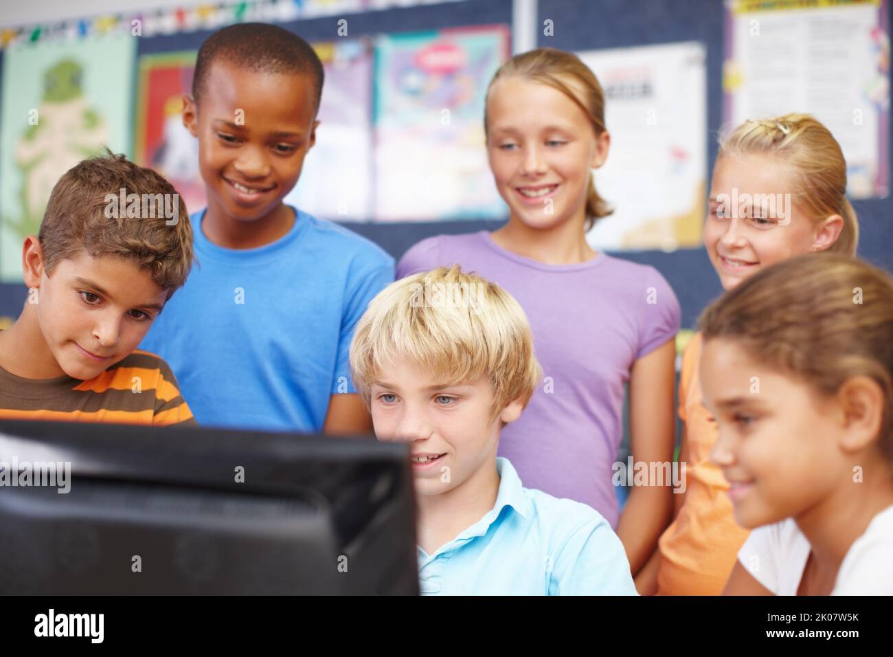 Enjoying the computer with friends. A group of young friends sitting ...