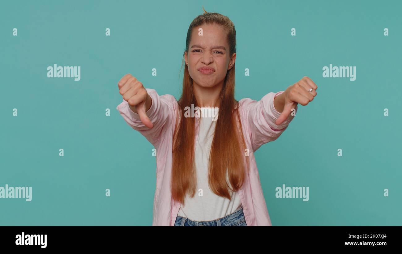 Upset lovely pretty teenager girl showing thumbs down sign gesture ...