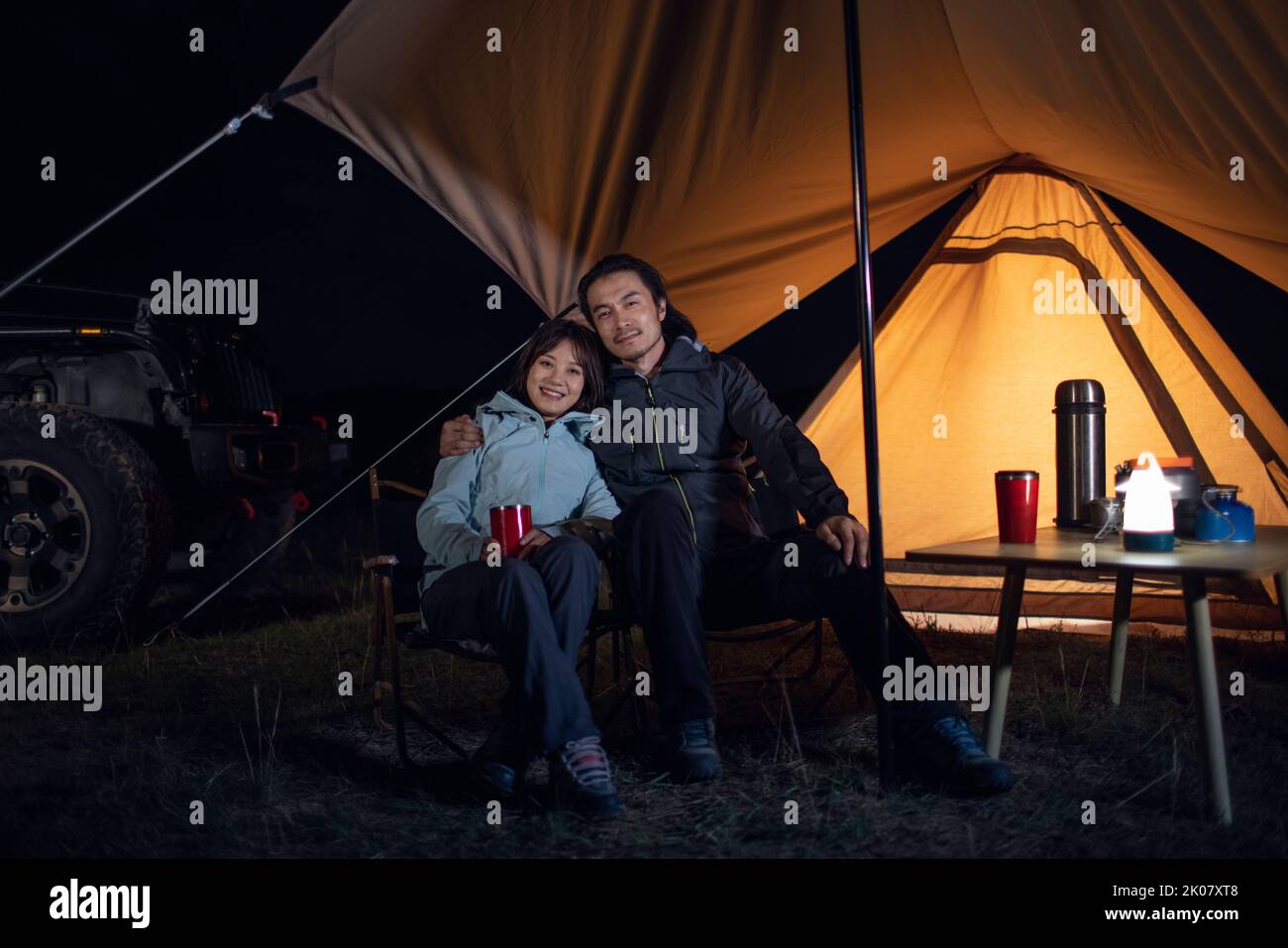 Happy Chinese couple camping outdoors Stock Photo - Alamy