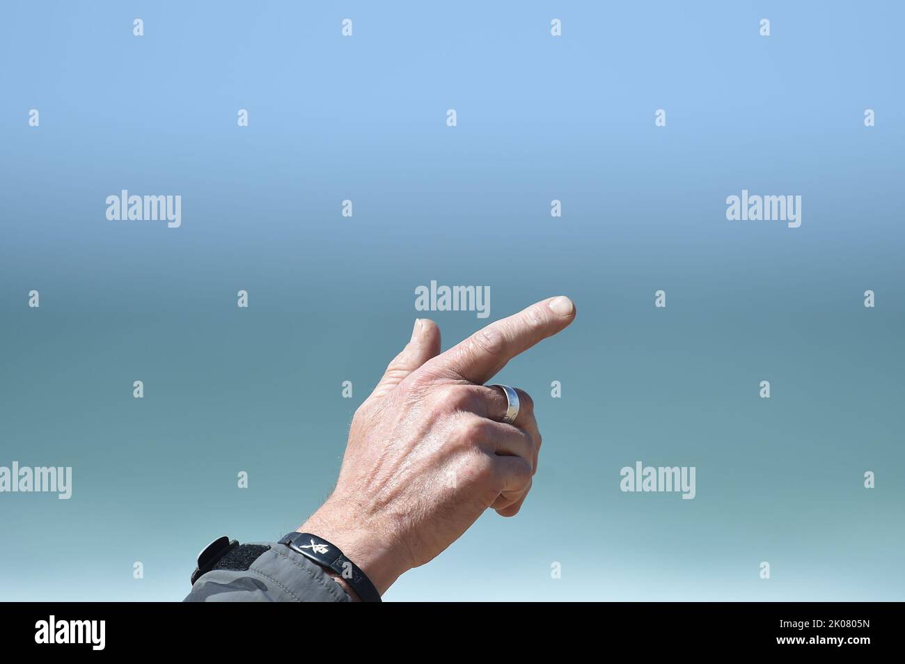 Male right hand finger pointing against blue sky clear background Stock ...