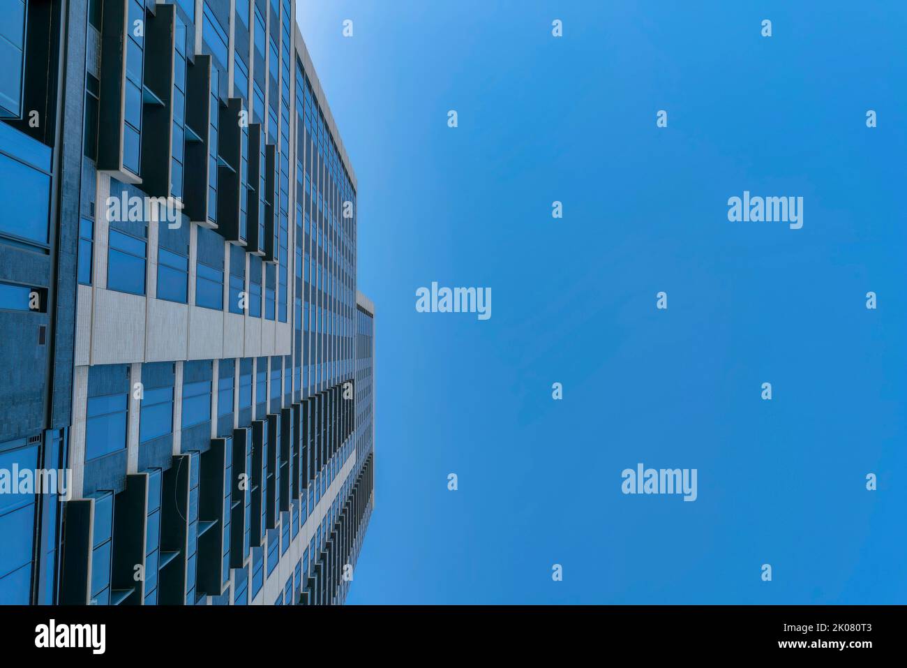 Looking up at clear blue sky and exterior of a modern building on a ...