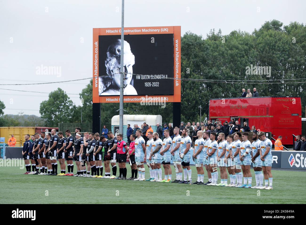 Players line up for a minute's silence in front of a big screen ...