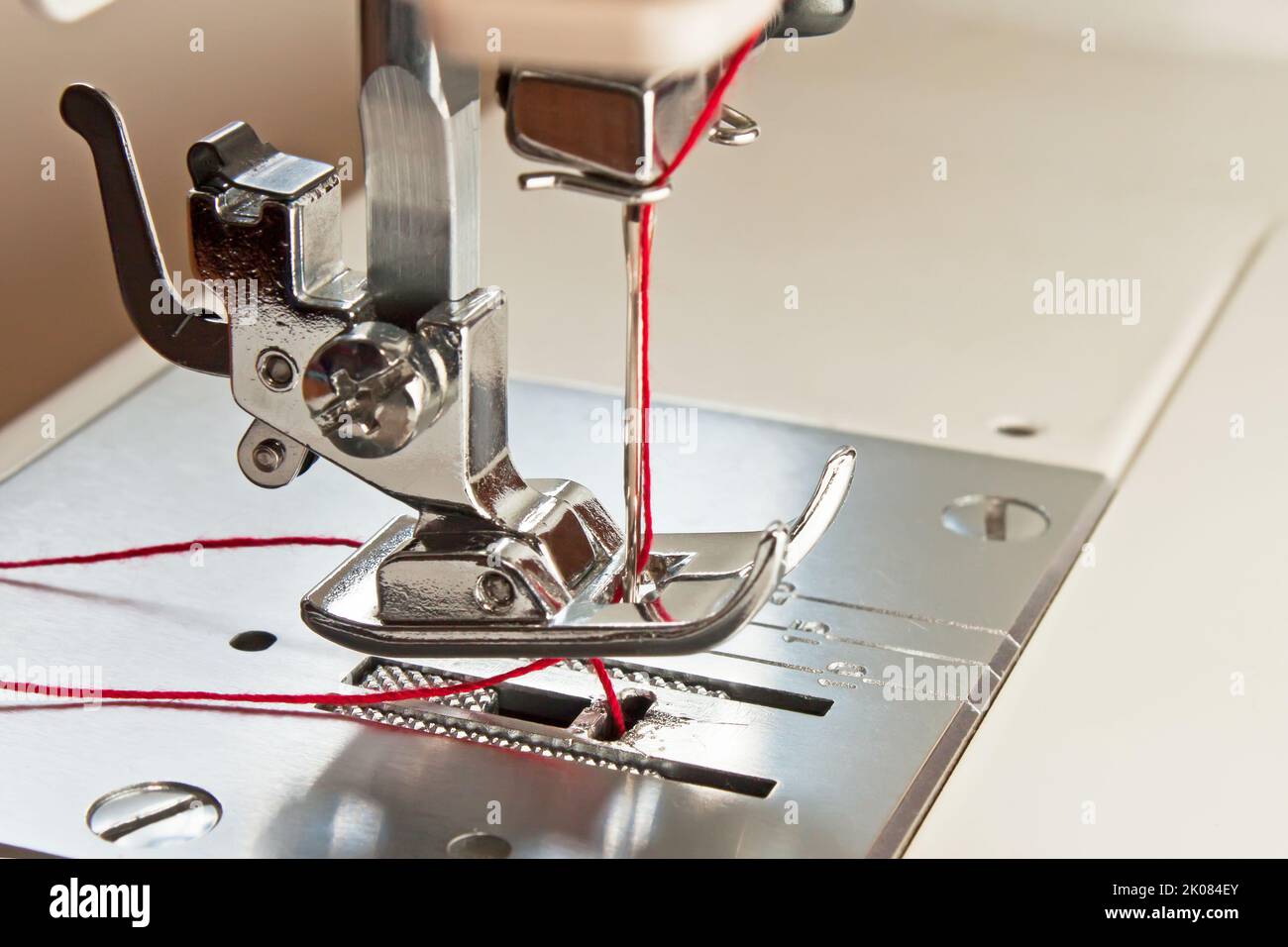 sewing machine presser foot and needle with red thread Stock Photo - Alamy