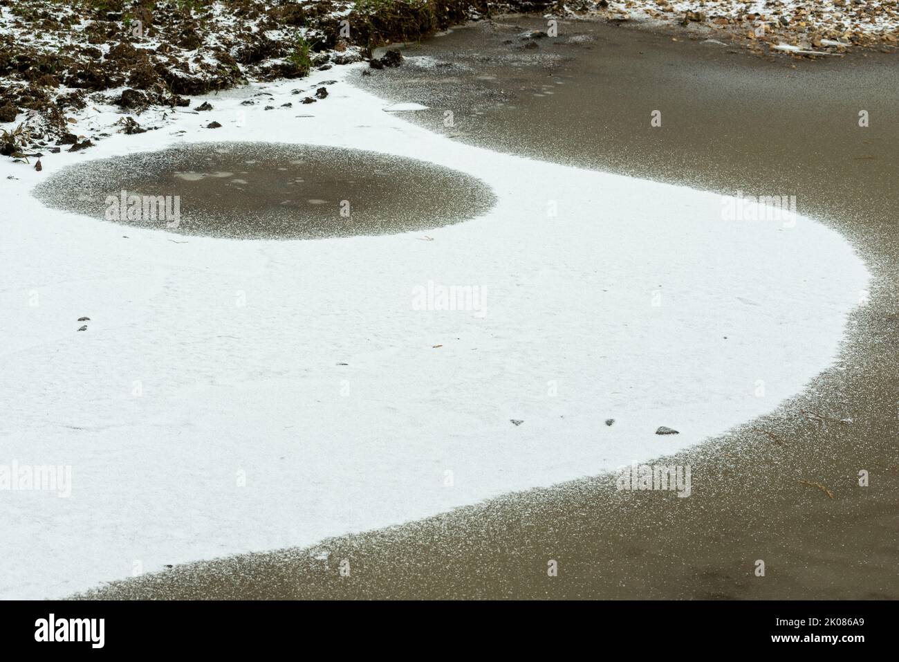 Dusting of snow on ice making a pattern with a circular eye shape Stock ...