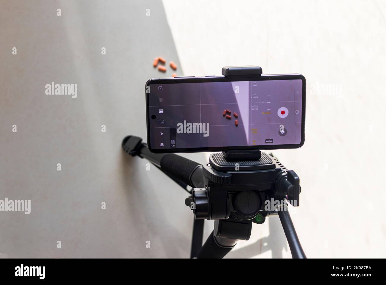 Close up shot of a phone on tripod capturing medicine on the surface ...