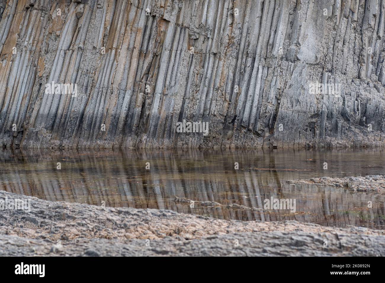 natural landscape with columnar basalt coastal rock reflected in the ...