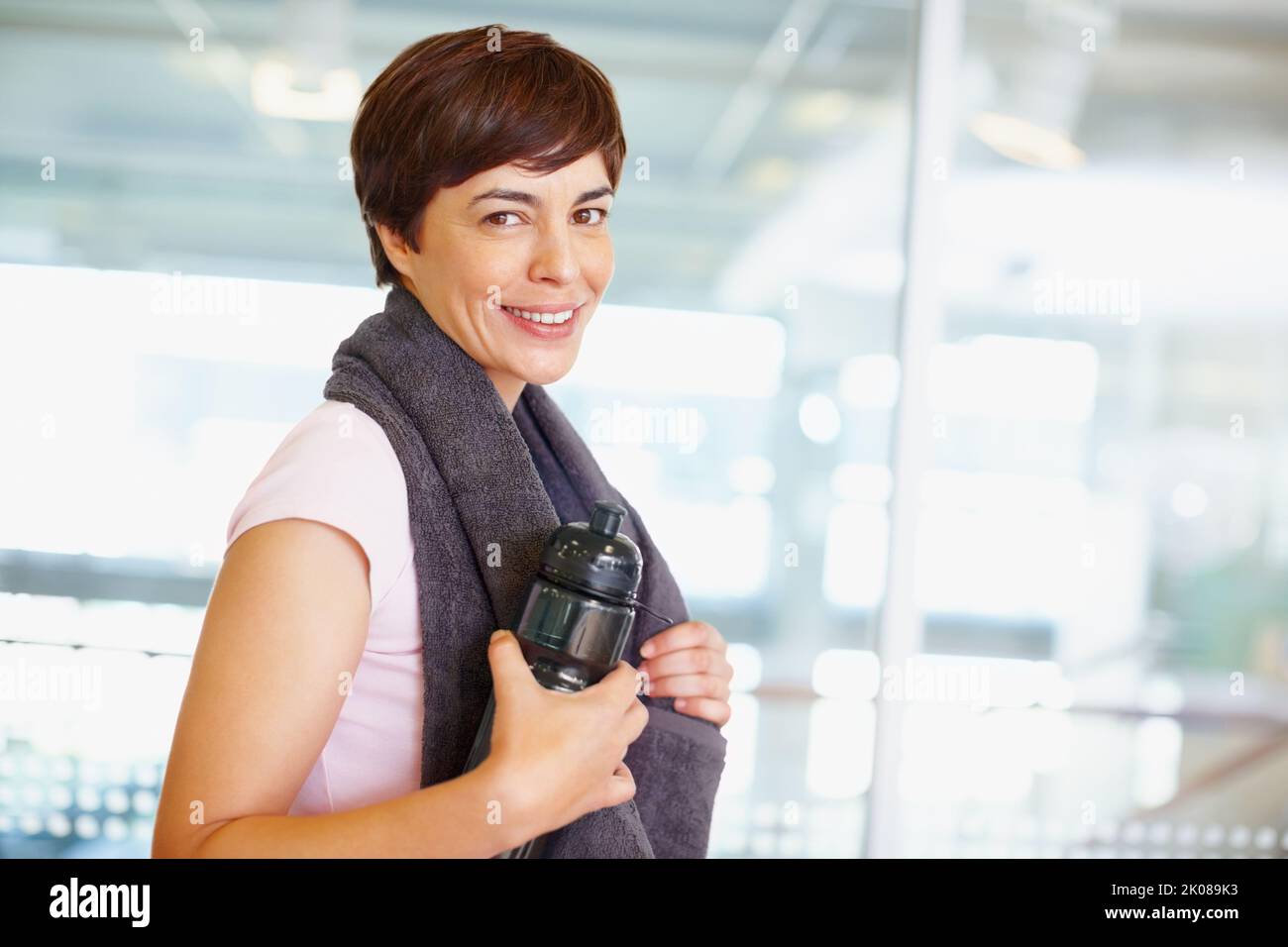 Woman taking a break during workout. Portrait of smiling woman taking a ...