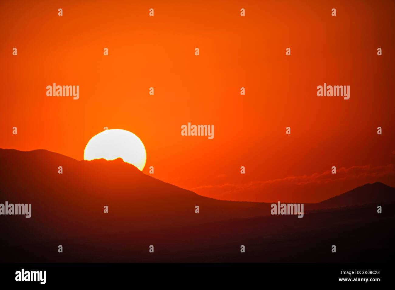 The sun rising over the horizon of the mountains Stock Photo - Alamy