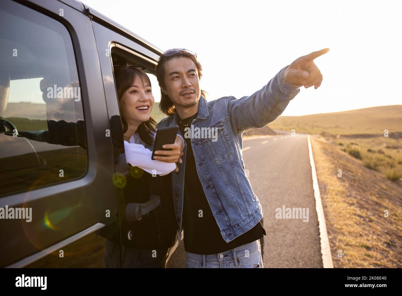 Happy Chinese couple enjoying road trip Stock Photo - Alamy