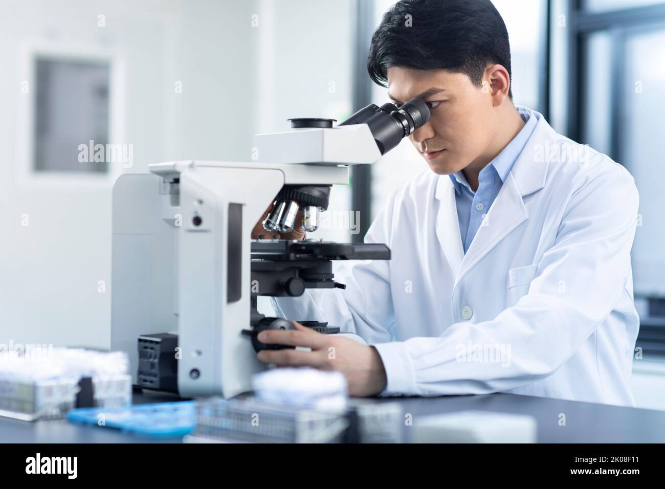 Chinese scientist looking through a microscope Stock Photo - Alamy