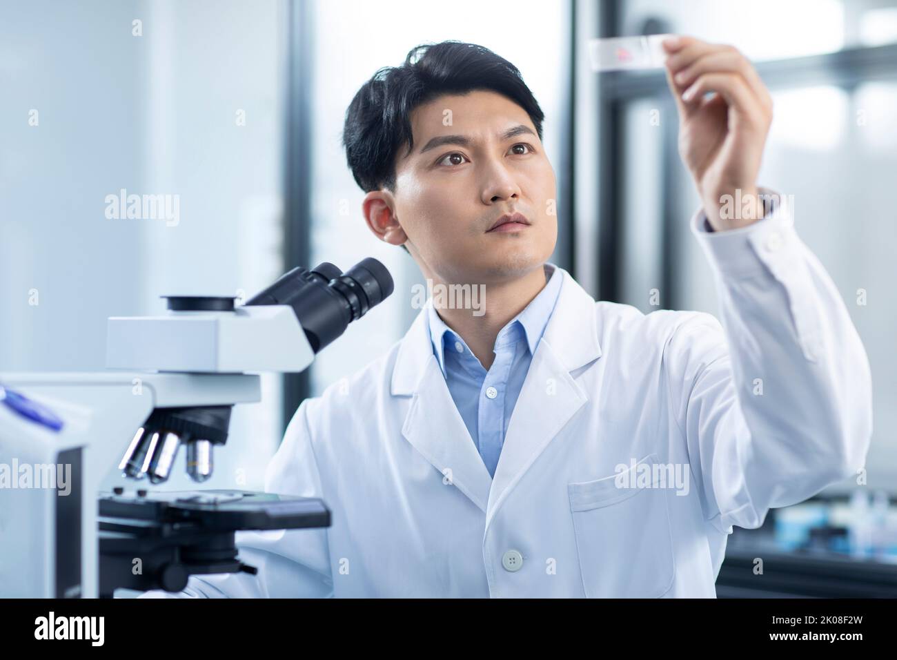 Chinese scientist looking at a microscope slide Stock Photo - Alamy