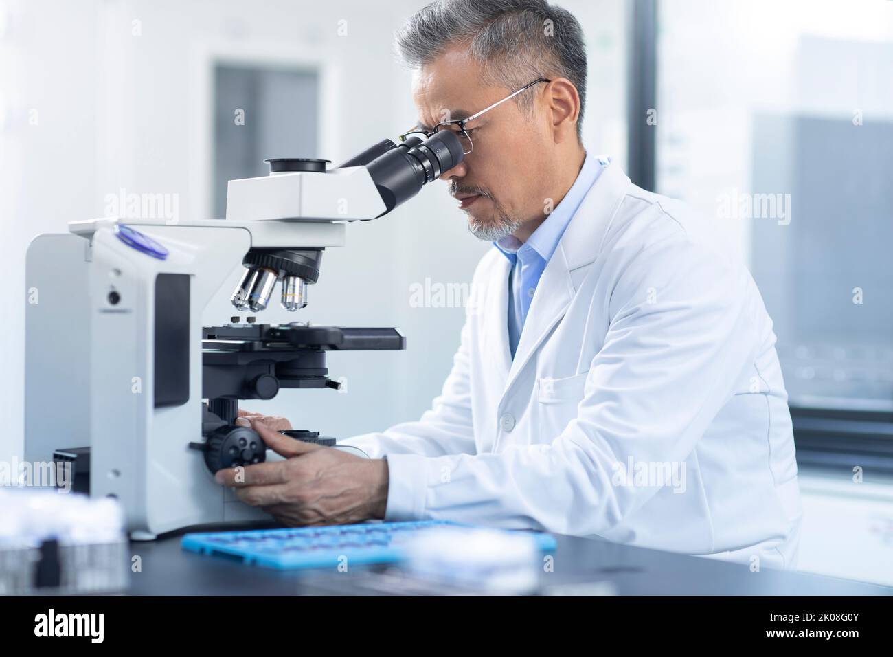 Chinese scientist looking through a microscope Stock Photo - Alamy