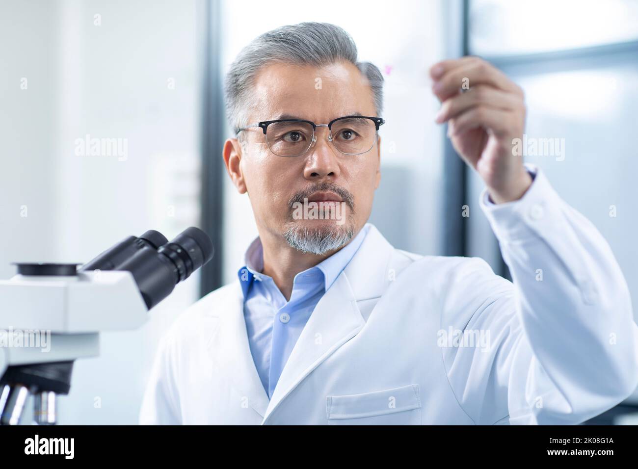 Chinese scientist looking at a microscope slide Stock Photo - Alamy