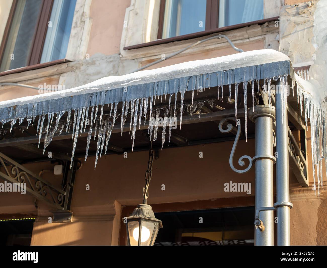 Sharp icicles a lot and melted snow hanging from eaves of roof and ...