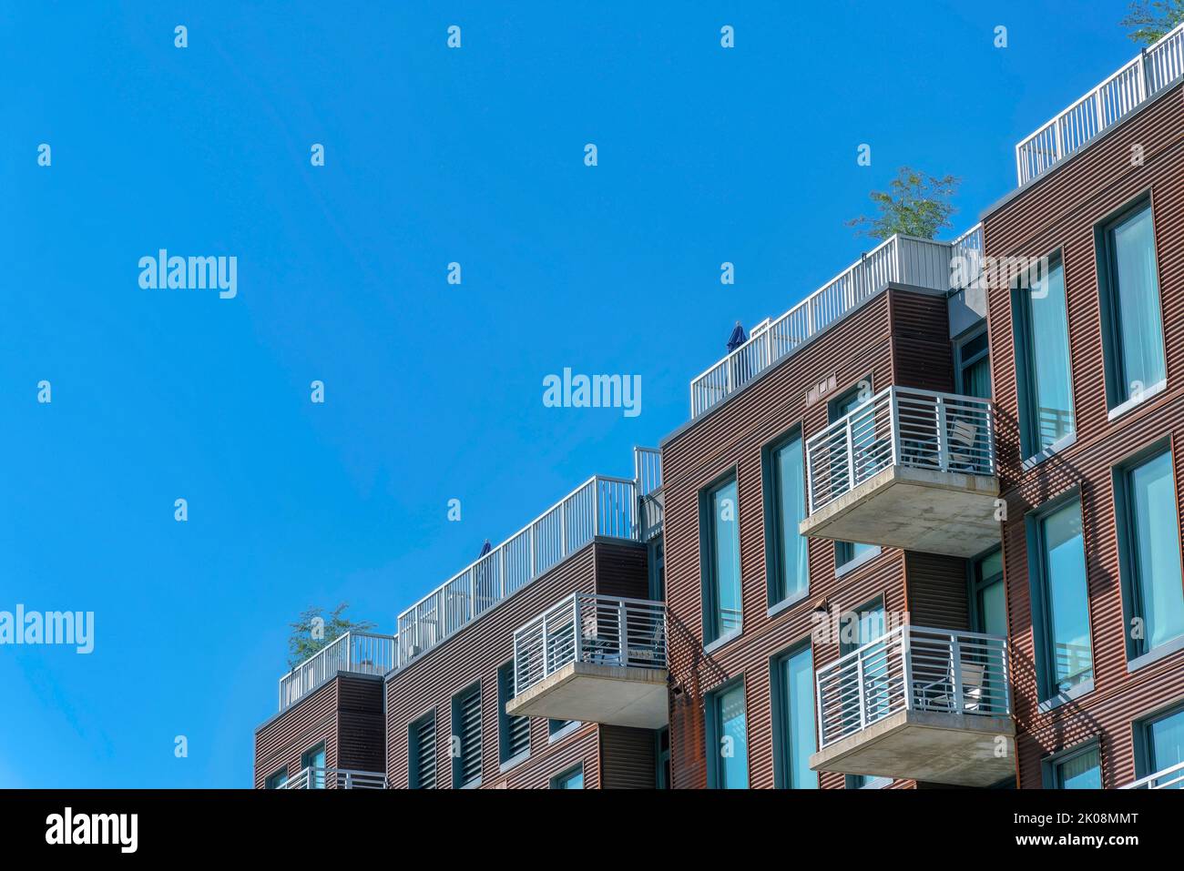 Exterior view of a luxury modern apartment with balconies against blue ...