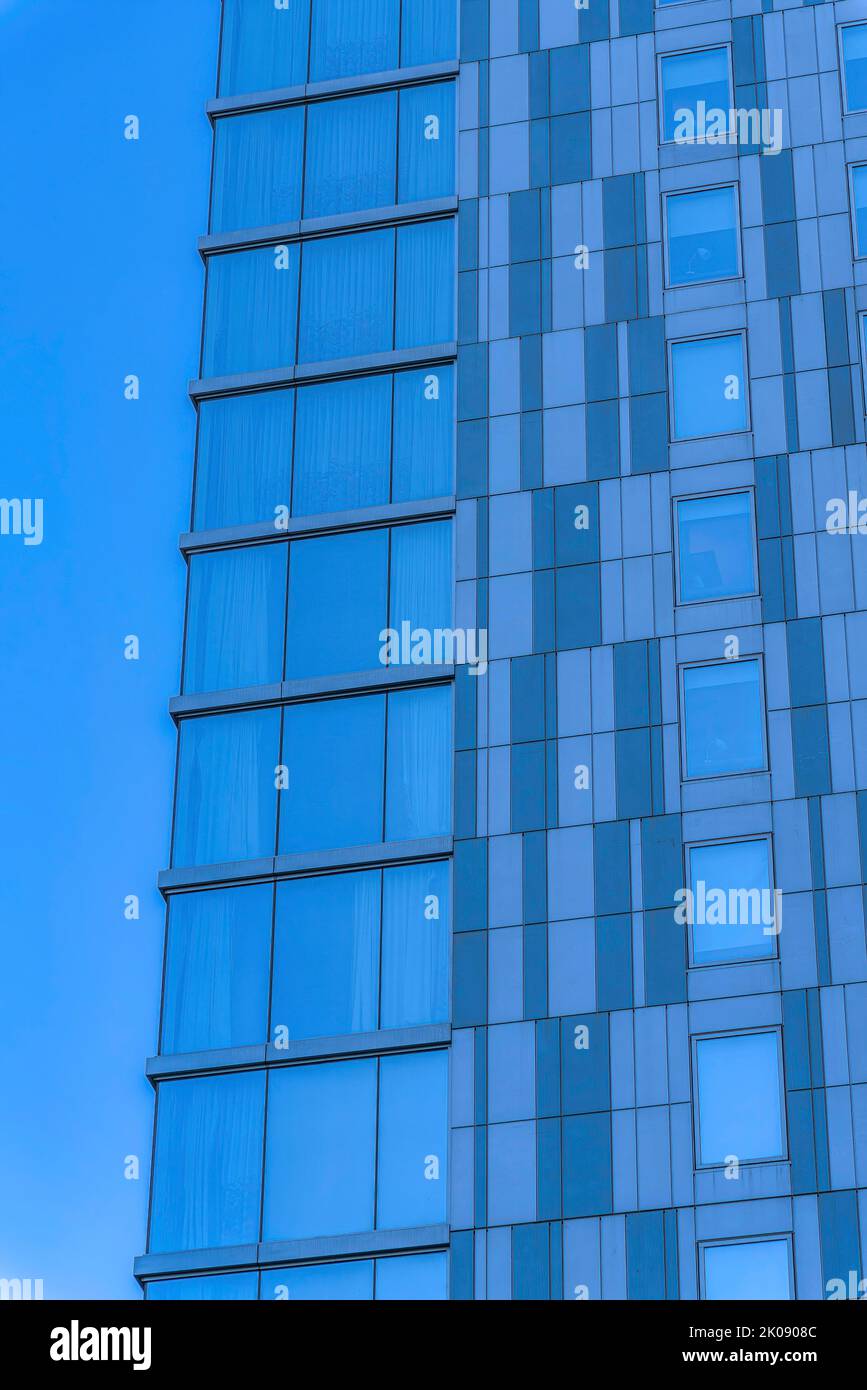 Tall modern building with glass facade that reflects the clear vibrant ...