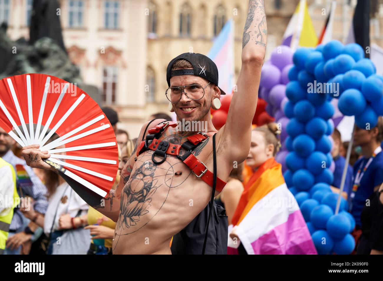 PRAGUE, CZECH REPUBLIC - AUGUST 13, 2022: LGBT man with red fan smiling ...