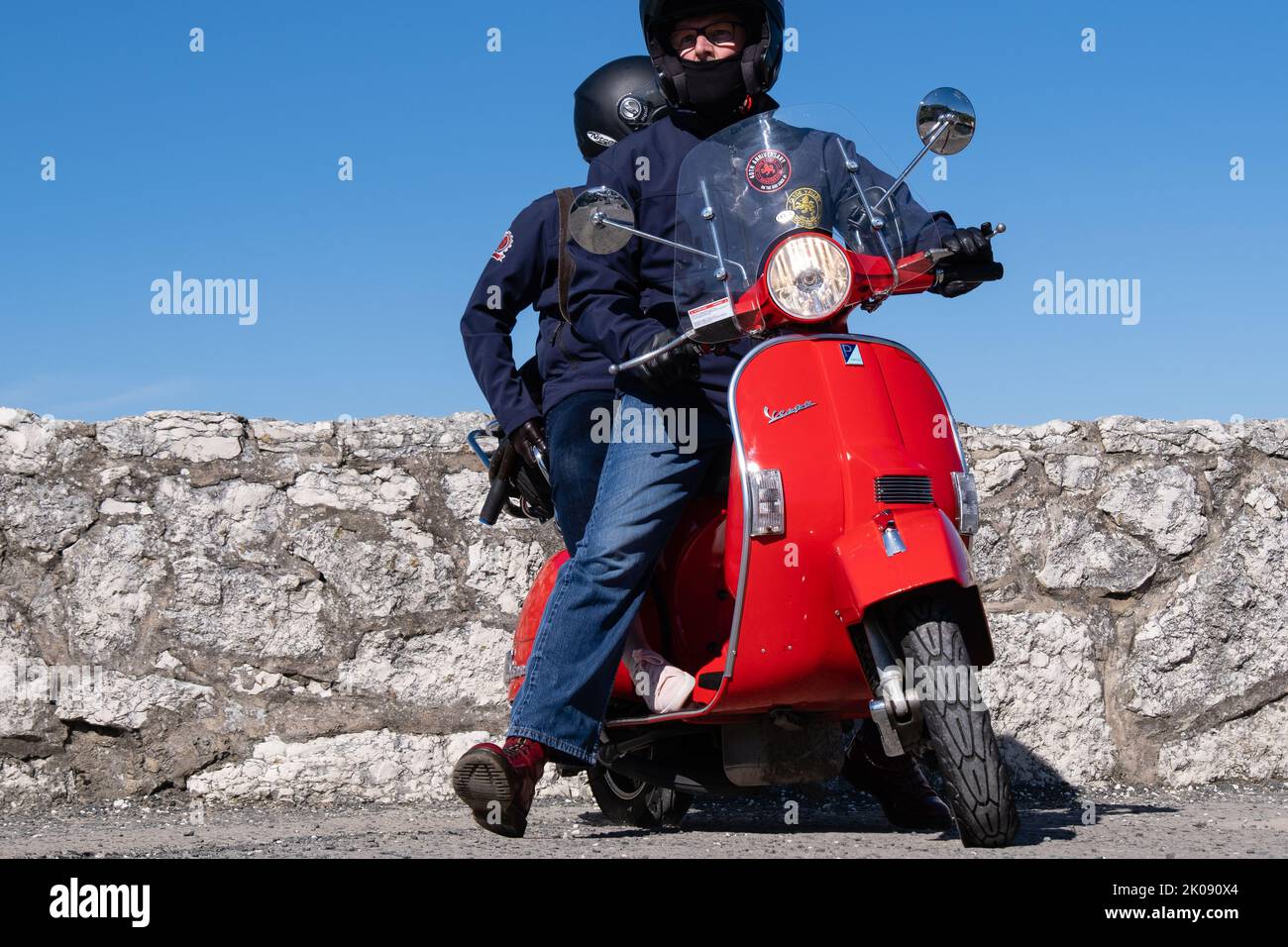 Vintage Vespa Scooter eye catching red, driver and pillion at scooter ...