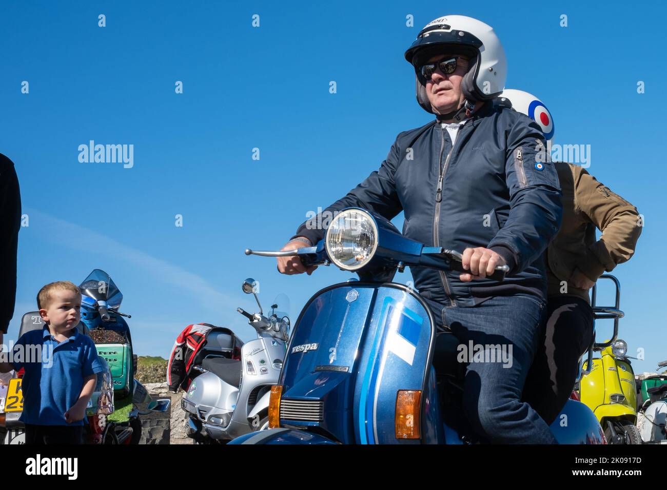 Man riding blue Vespa scooter with passenger at annual Gathering of the Clans scooter rally ...
