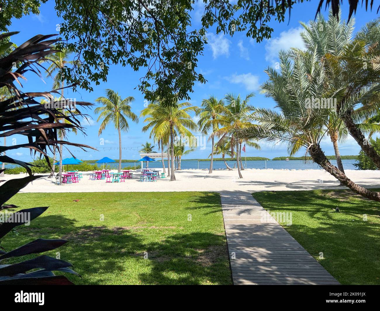 A typical beach restaurant with colorful tables, chairs and umbrellas ...
