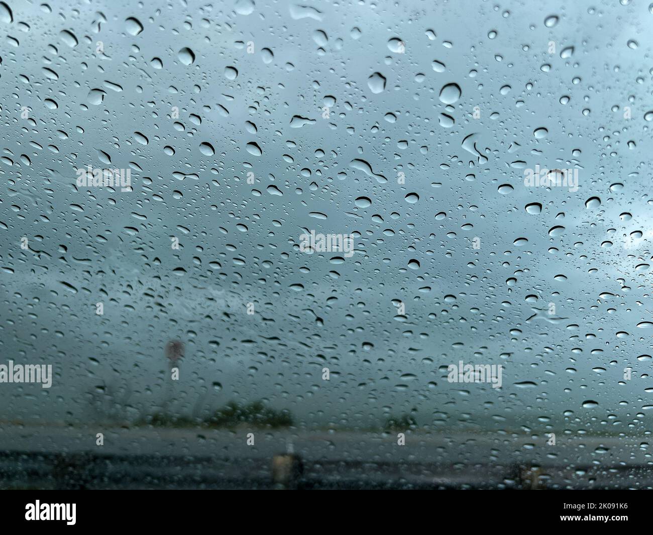 Rain on a car window with a blurred background during a storm in the ...
