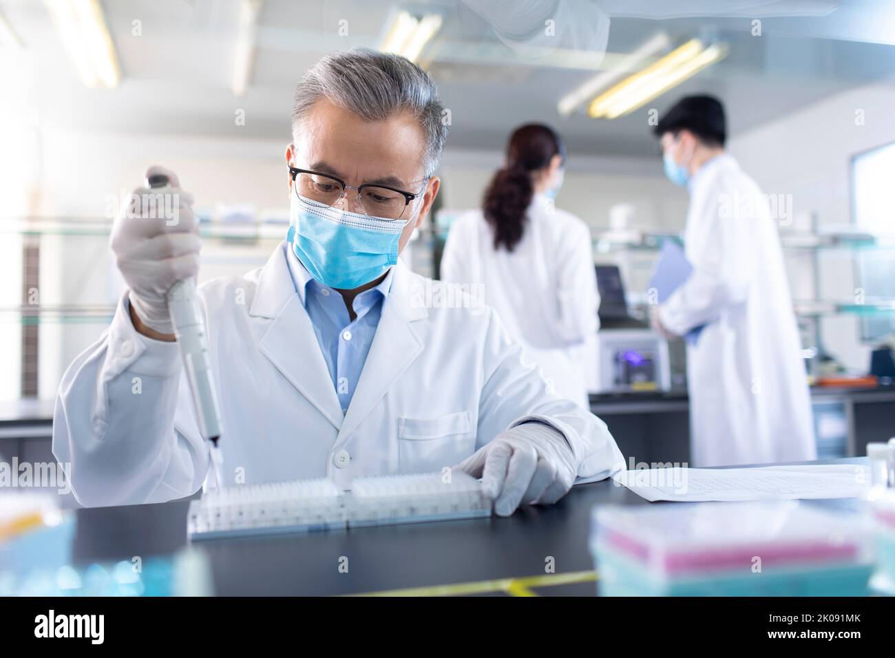 Three Chinese researchers working in laboratory Stock Photo - Alamy