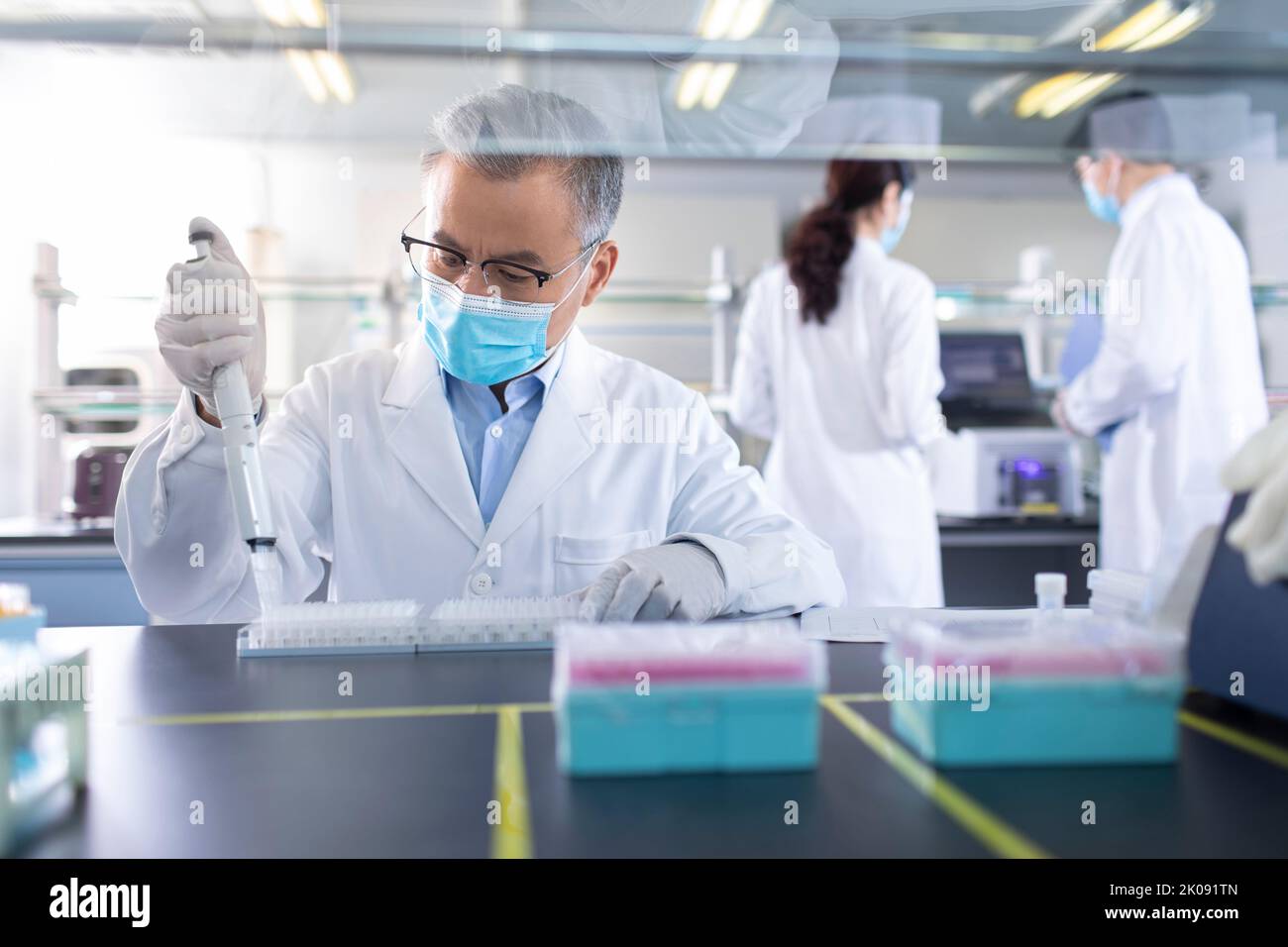 Three Chinese researchers working in laboratory Stock Photo - Alamy