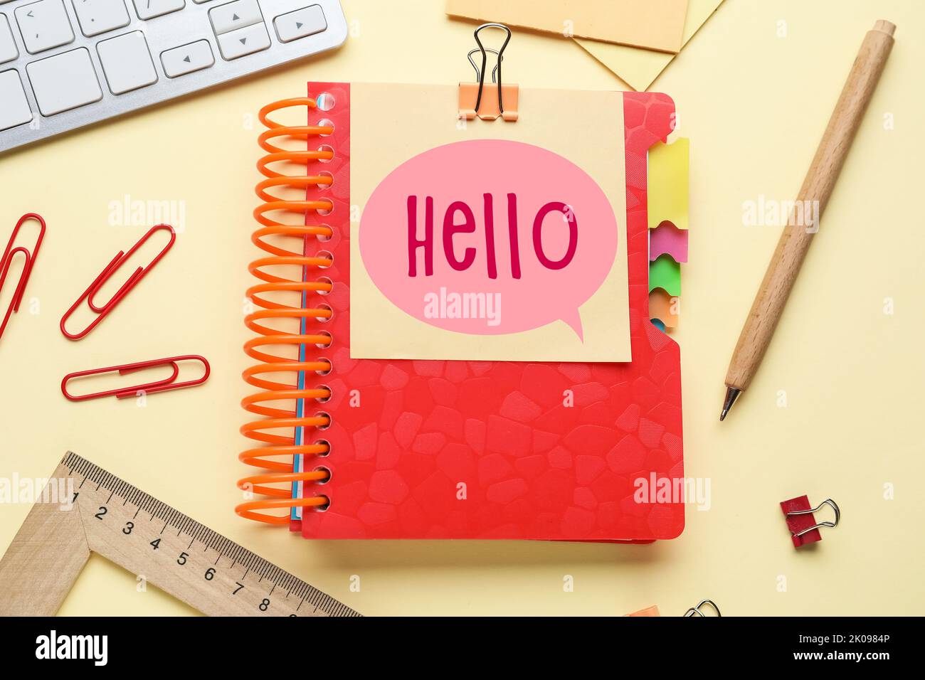 Sticky note with word HELLO, stationery and PC keyboard on yellow ...