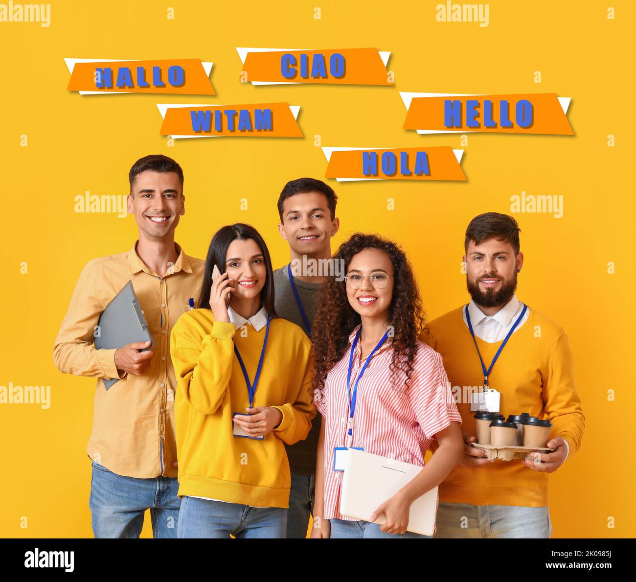 Team of young workers and words HELLO in different languages on yellow ...